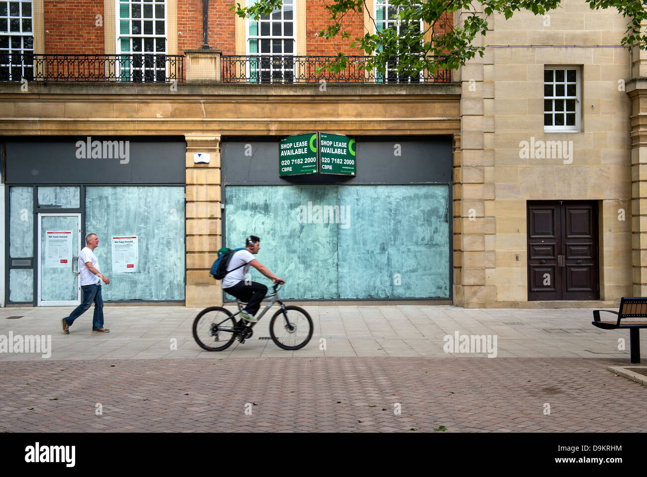 Empty shop on the high street with two passers by Stock Photo - Alamy