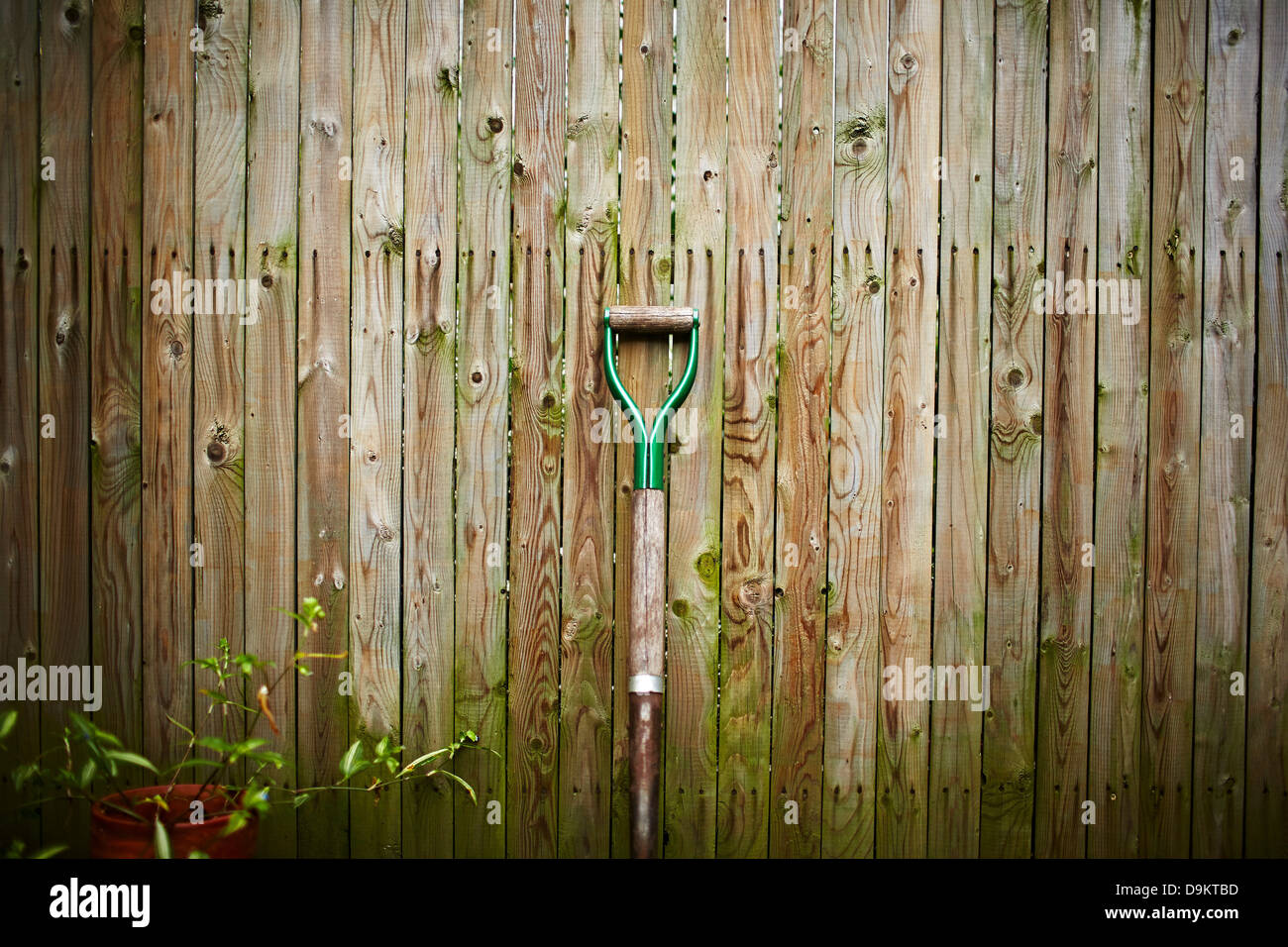 Wooden fence with garden spade Stock Photo - Alamy