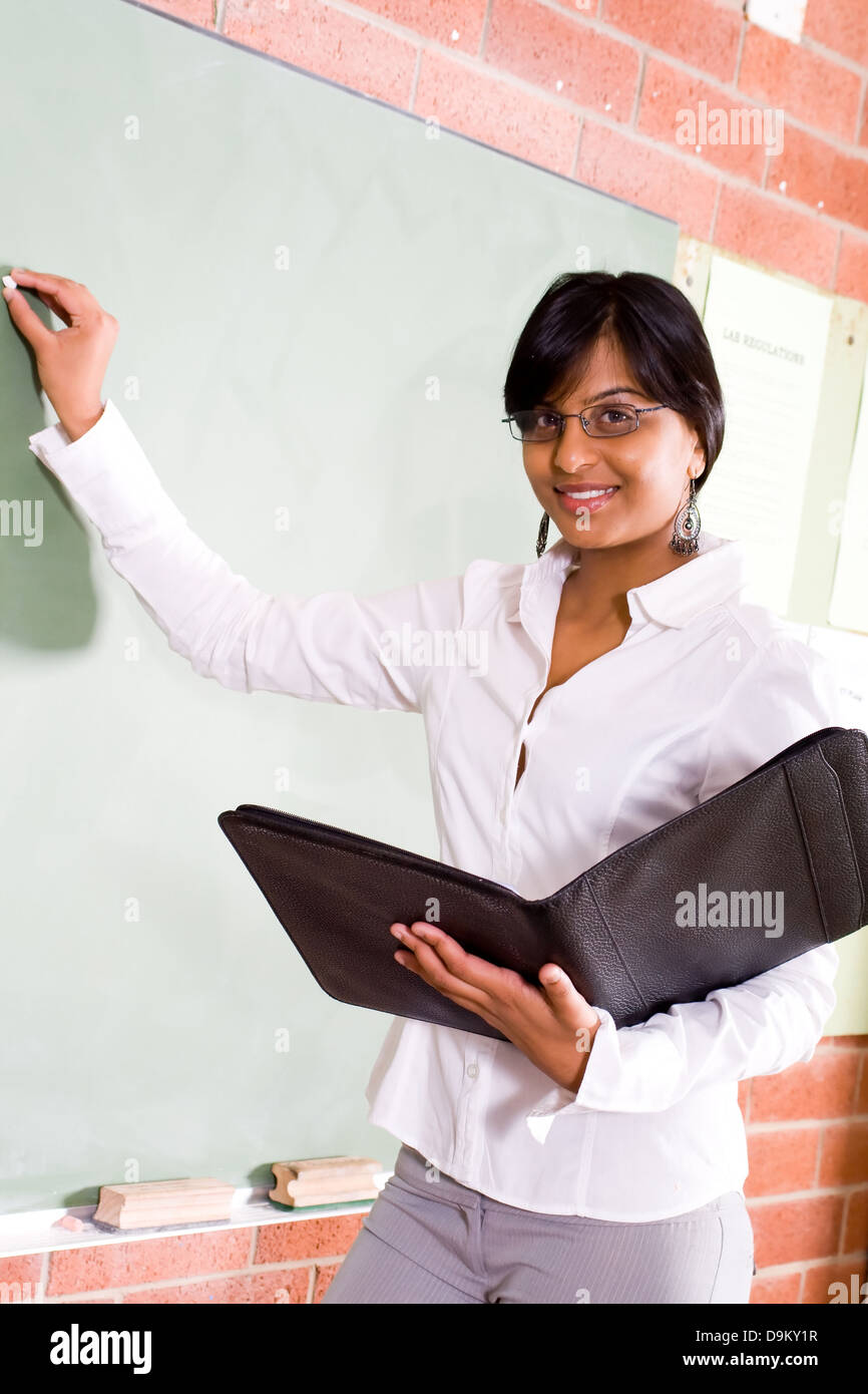 young beautiful school teacher writing on blackboard Stock Photo - Alamy