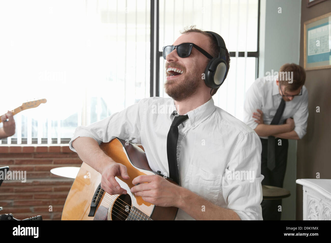 Young guitarist laughing in rehearsal room Stock Photo - Alamy