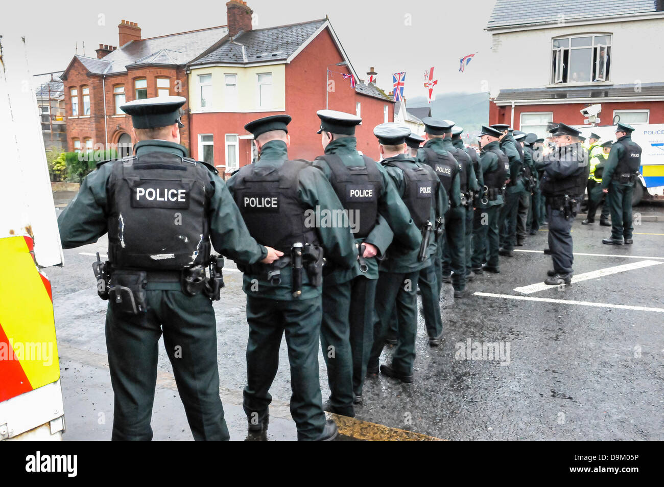Uniformed PSNI police officers wearing high visibility jackets form a ...