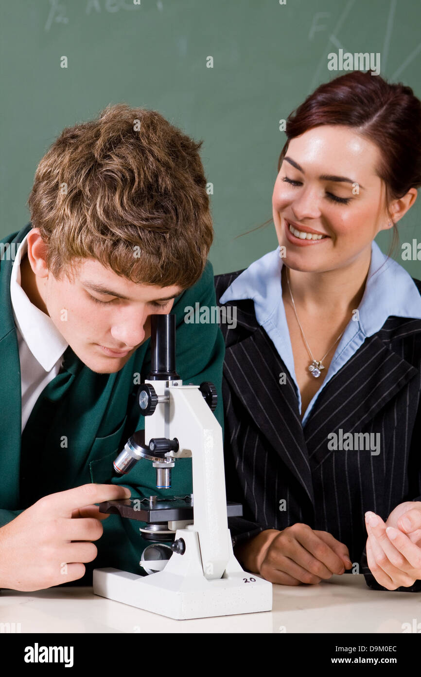 high school teacher teaching microscope to her student Stock Photo - Alamy