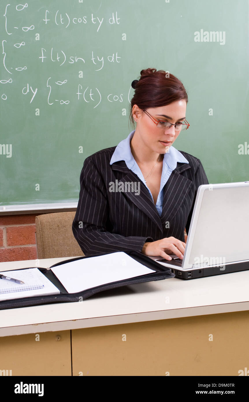 young female teacher working in classroom Stock Photo - Alamy