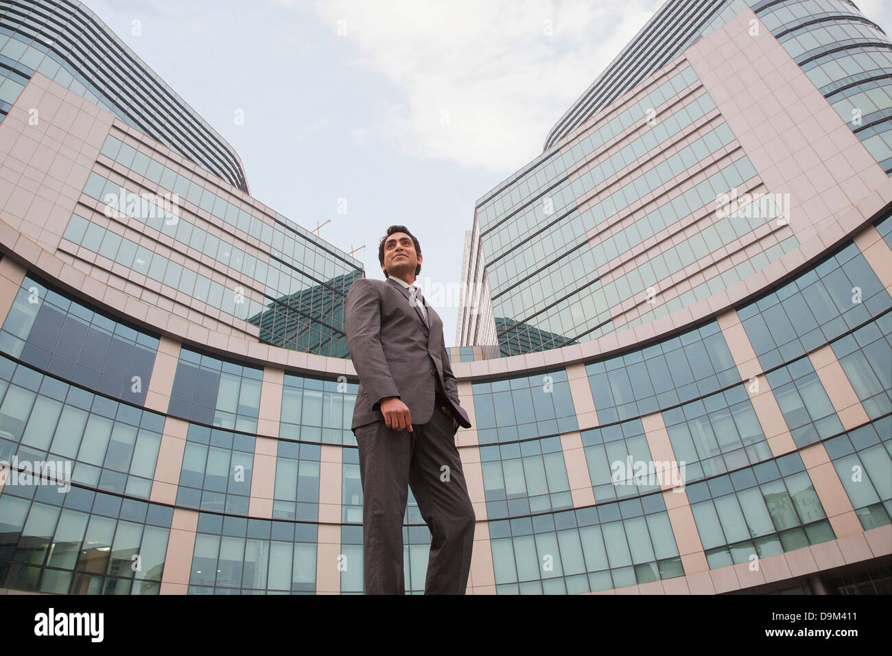 Businessman standing outside an office building Stock Photo - Alamy