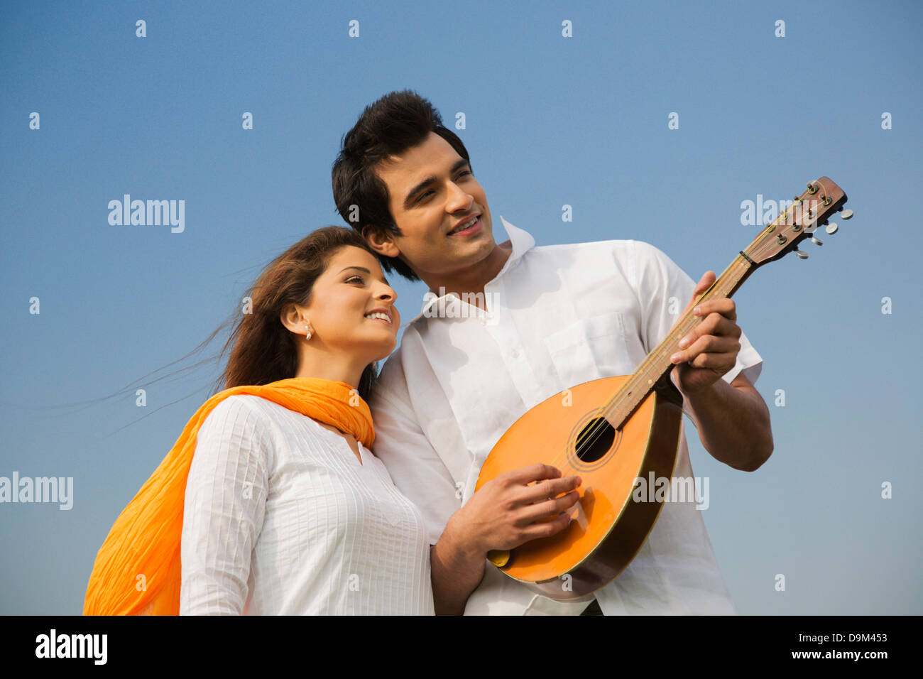 Couple playing a mandolin and smiling Stock Photo - Alamy