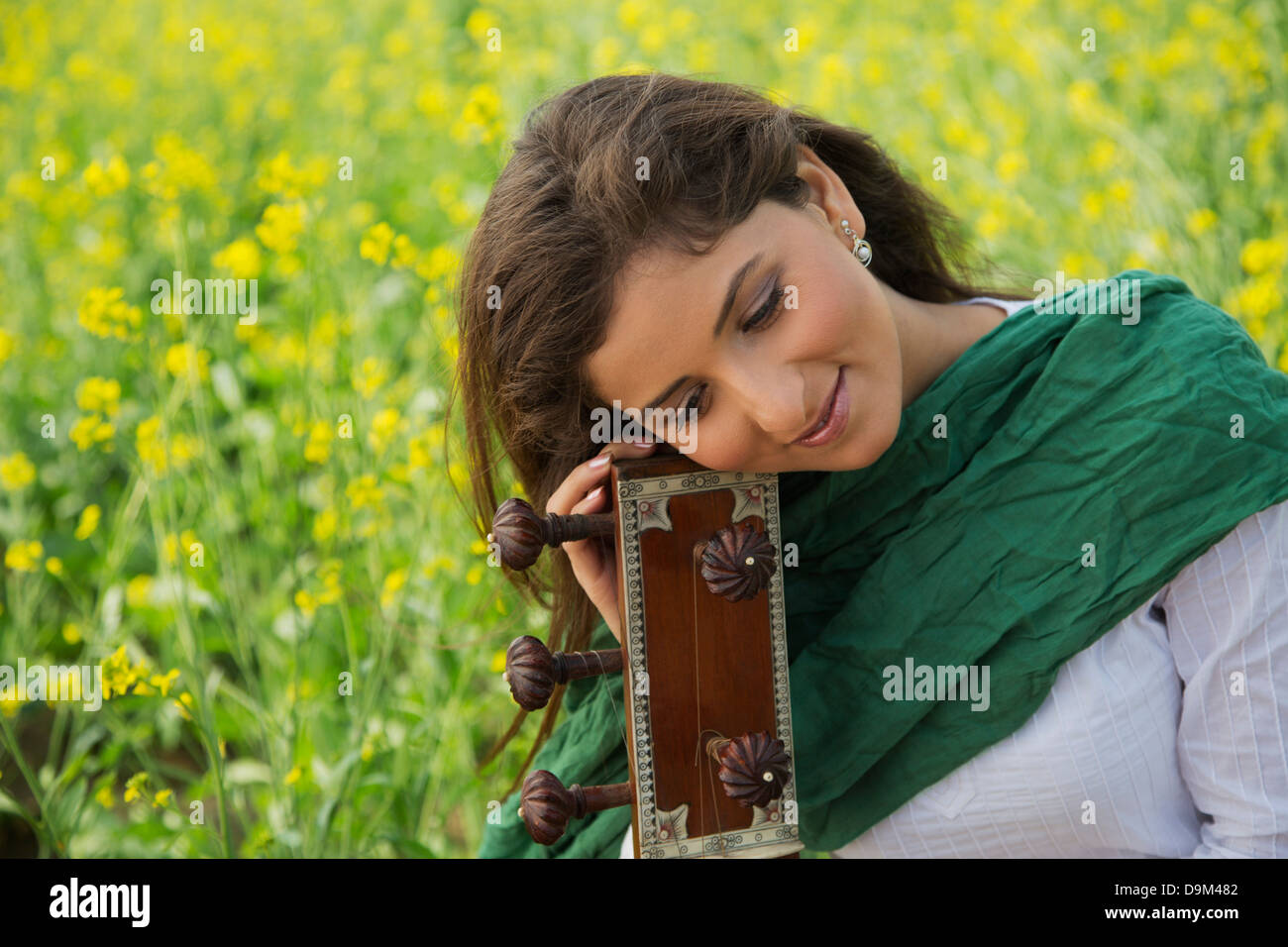 Woman playing a sitar and smiling Stock Photo - Alamy