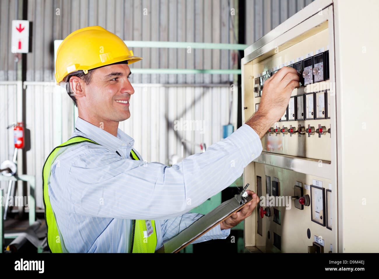 industrial machine operator adjusting machine settings Stock Photo - Alamy