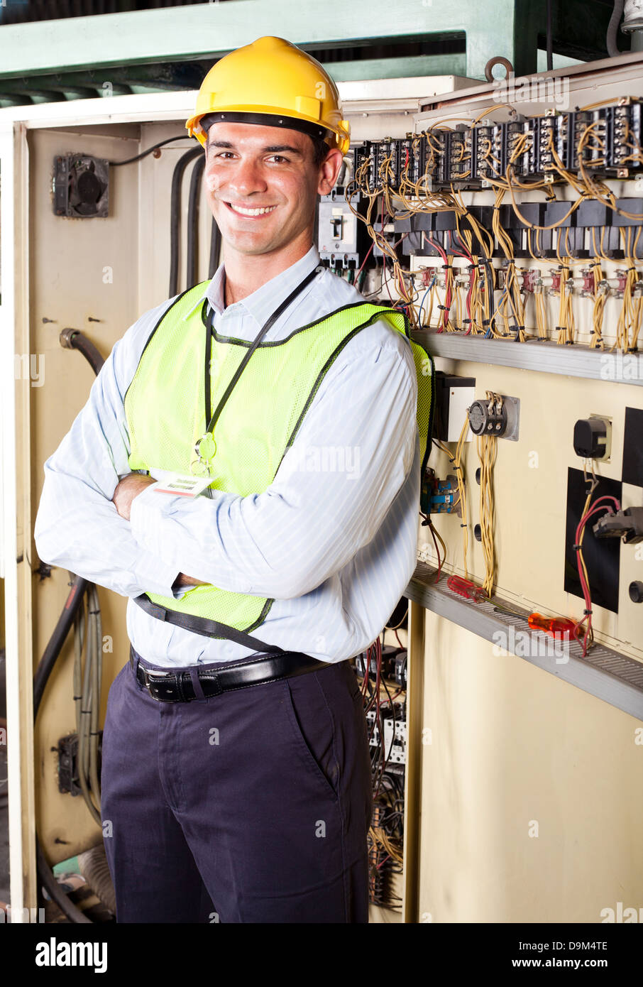 male Caucasian industrial electrician portrait in front of machinery ...