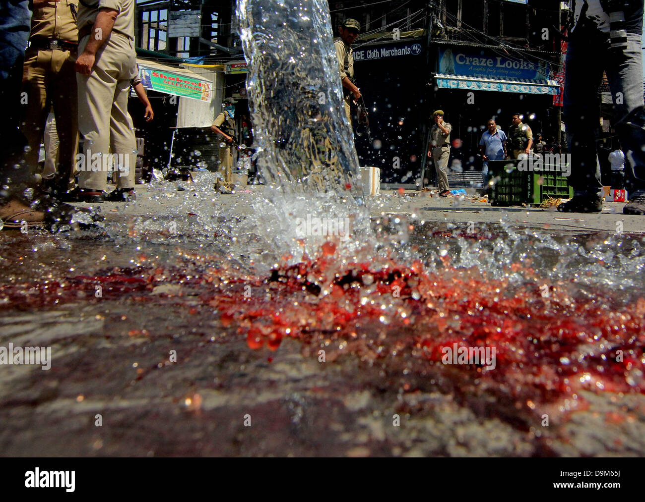 Srinagar, Indian Kashmir. June 22, 2013 - Locals washing the blood ...