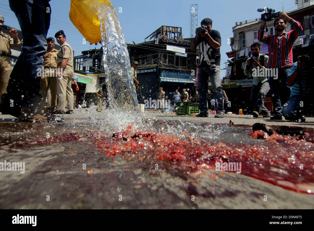 June 22, 2013 - Srinagar, Kashmir, India - Locals wash the blood ...