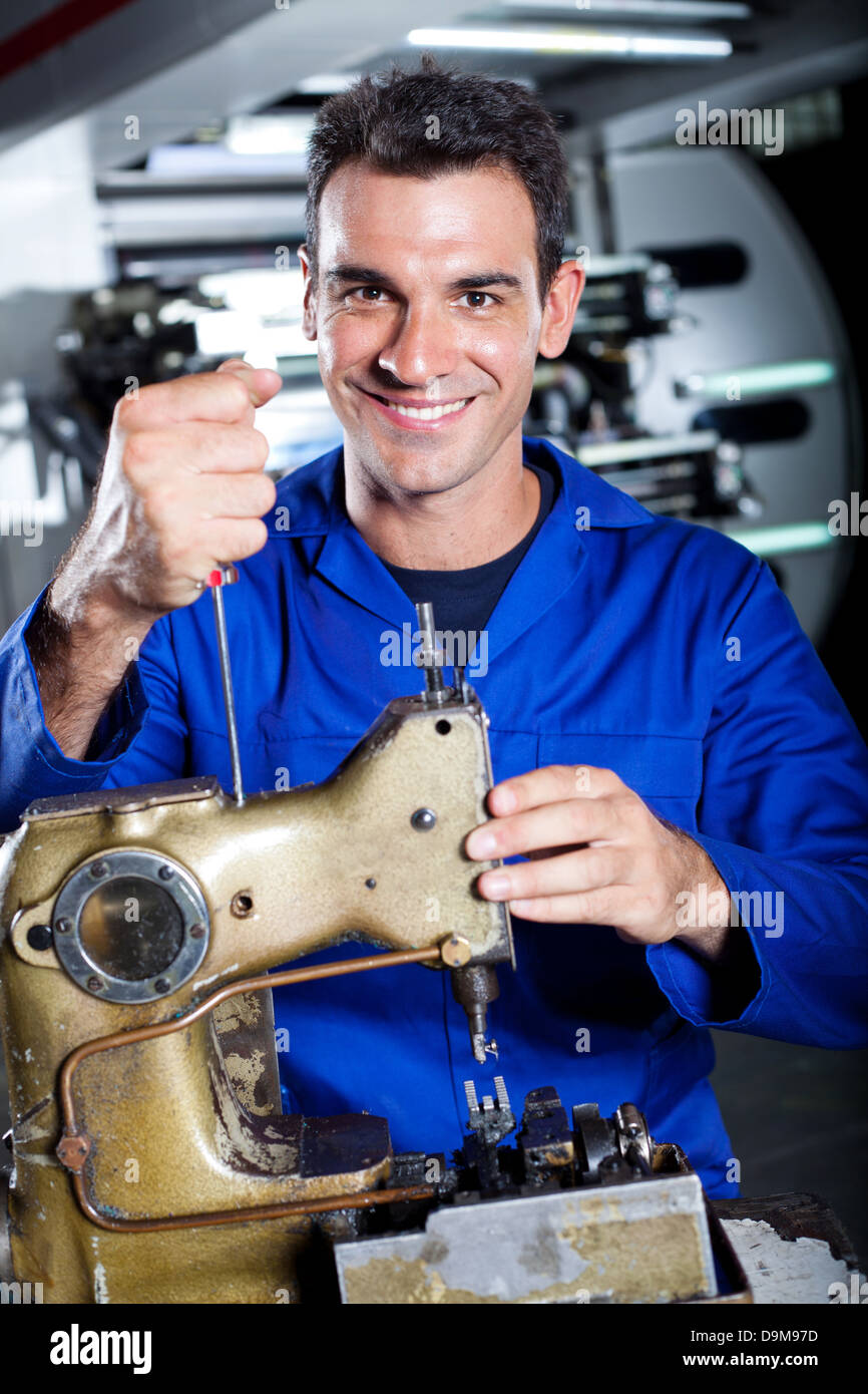happy industrial mechanic repairing sewing machine Stock Photo - Alamy