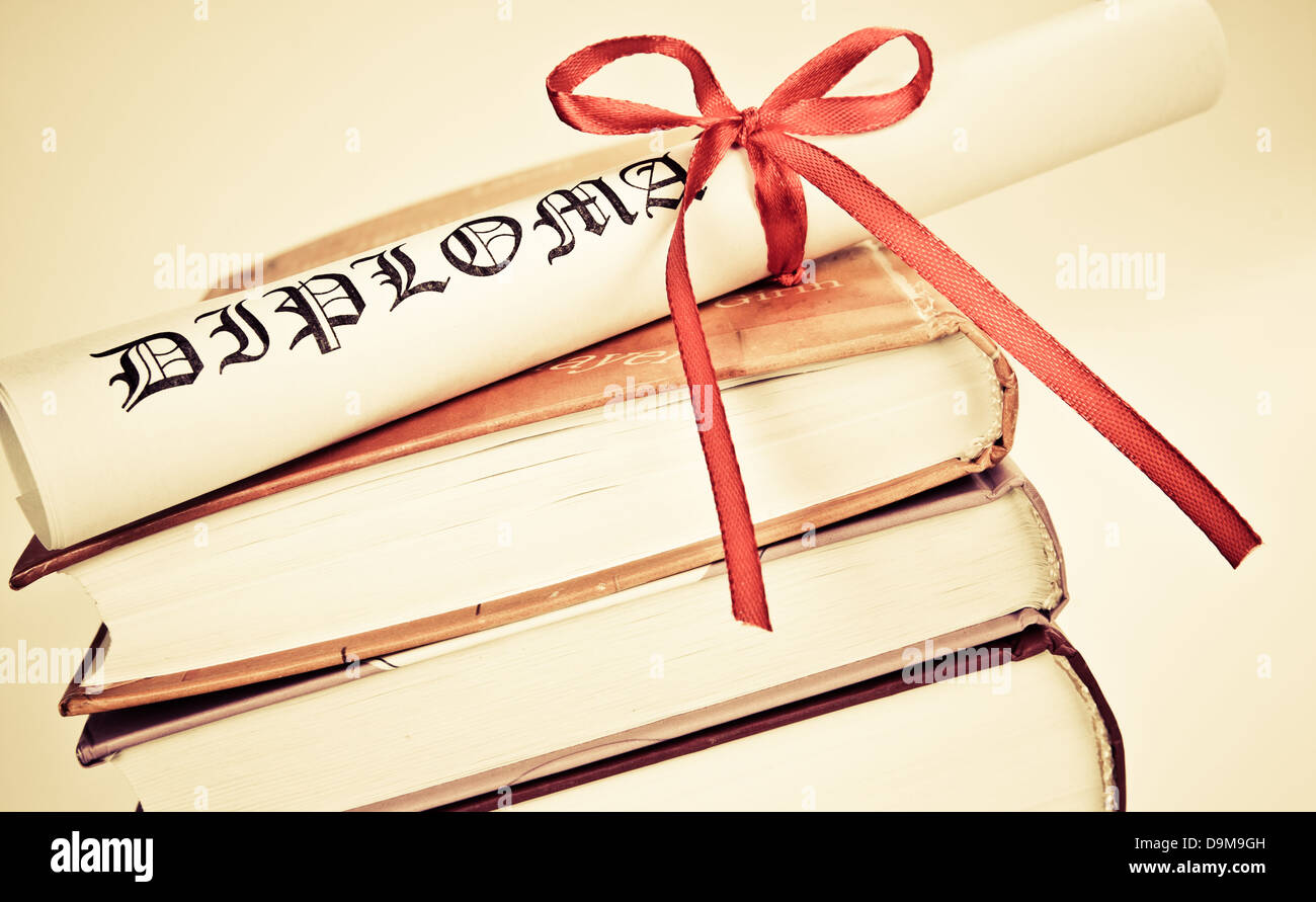 Diploma with red ribbon and books Stock Photo - Alamy
