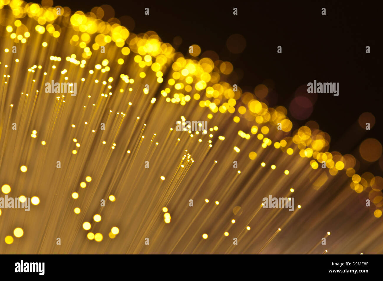 Fibre optics strands transmitting yellow light Stock Photo - Alamy