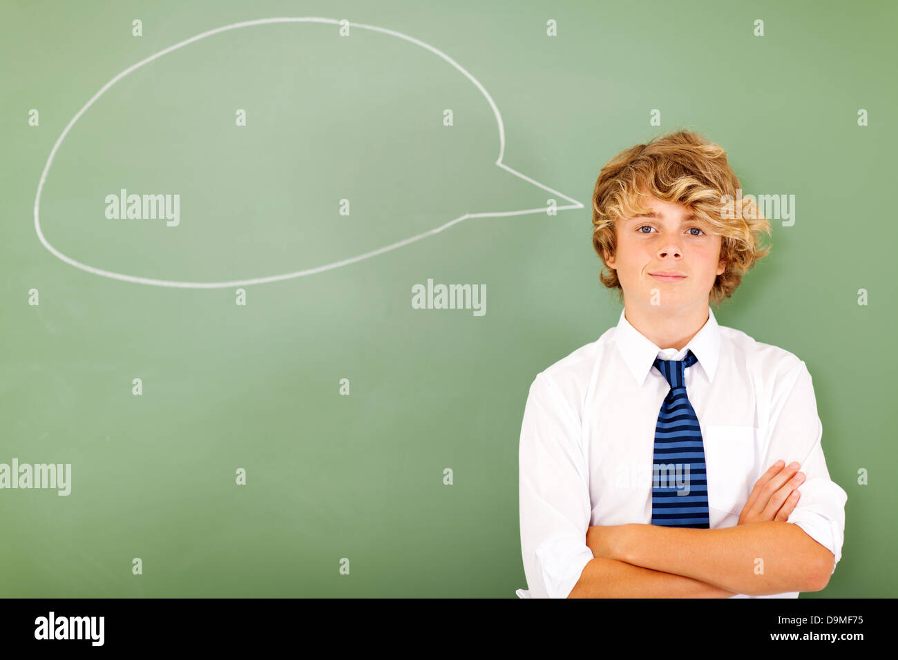 young high school boy in front of chat box drawn on chalkboard thinking ...