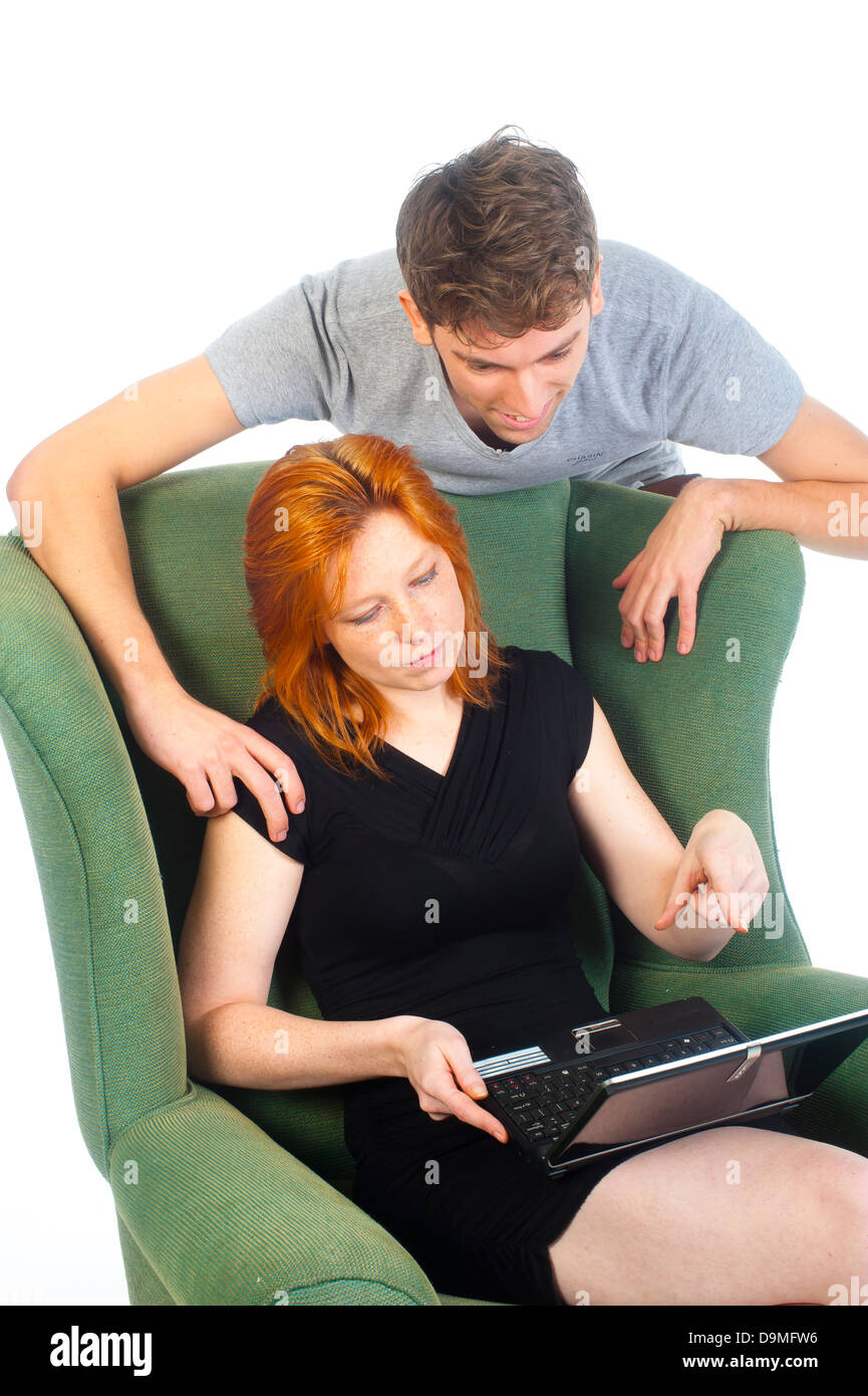 a pretty woman is helping a man with the use of the computer Stock ...