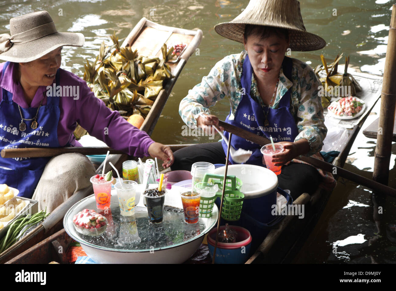Juice merchant preparing juice for customer at Damnoen Saduak floating ...