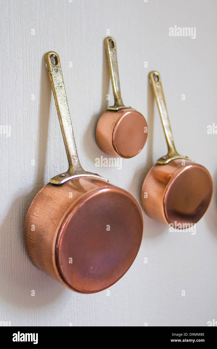 Copper pans hanging on a wall Stock Photo - Alamy