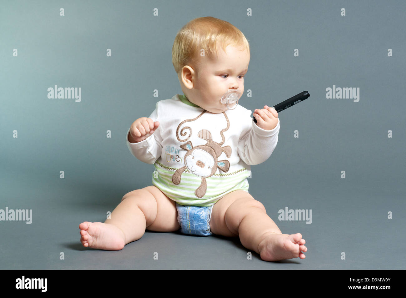 blond baby playing with a marker Stock Photo - Alamy
