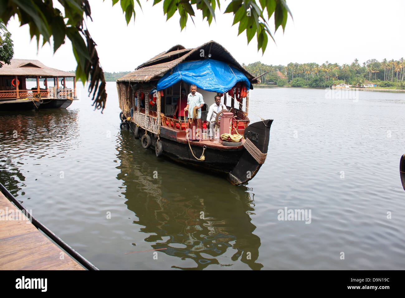 A traditional houseboat sails on the backwaters of Kerala, India Stock ...