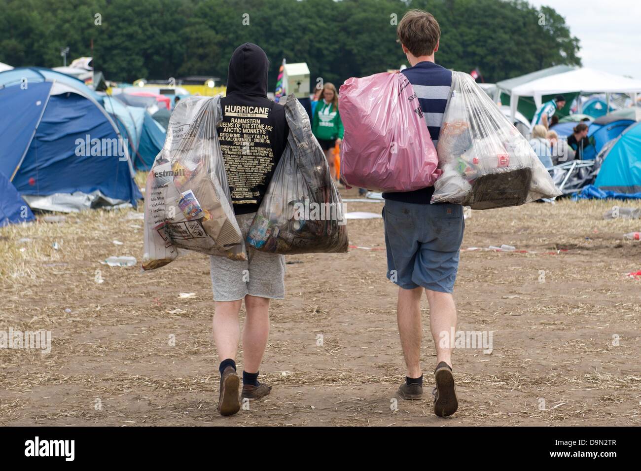 Two festival visitors carry bags of garbage at the Hurricane Festival ...
