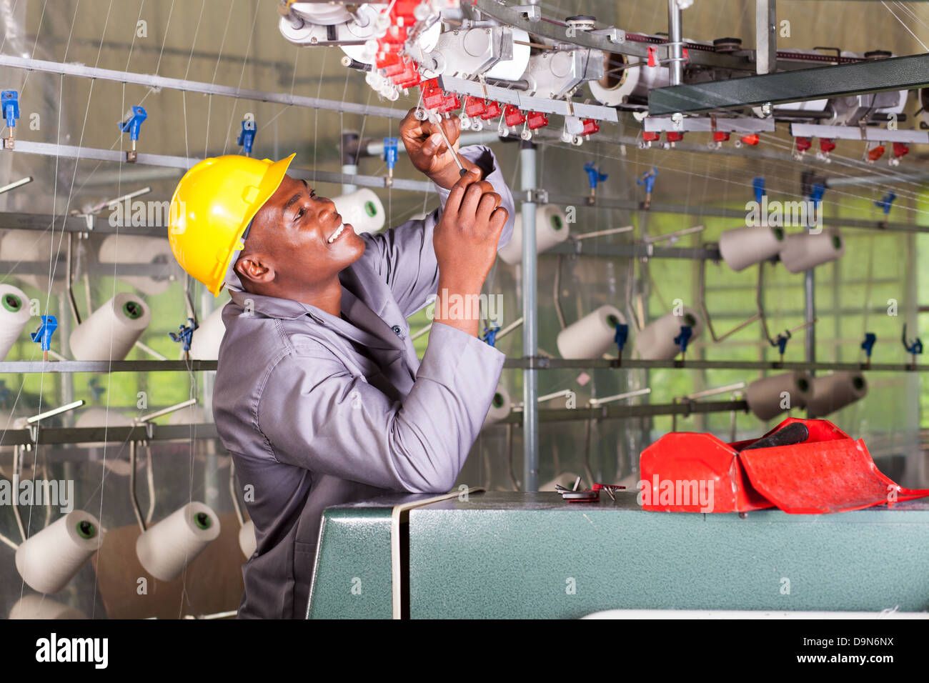 African American textile mechanic repairing weaving loom Stock Photo ...