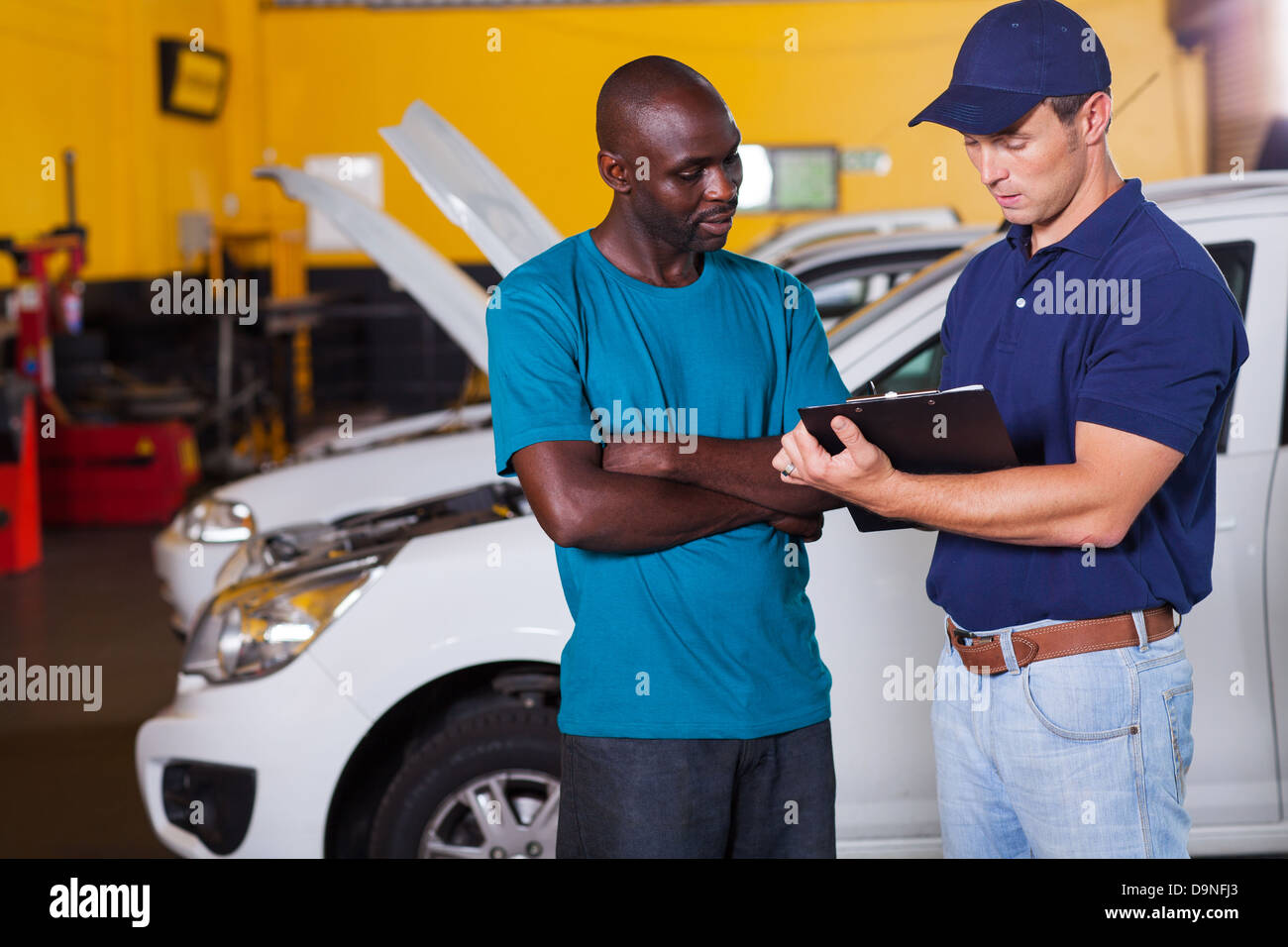 African man inside vehicle workshop with auto mechanic Stock Photo - Alamy