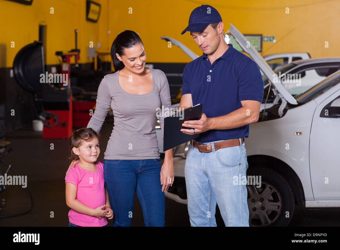 mother and daughter in garage with auto mechanic Stock Photo - Alamy
