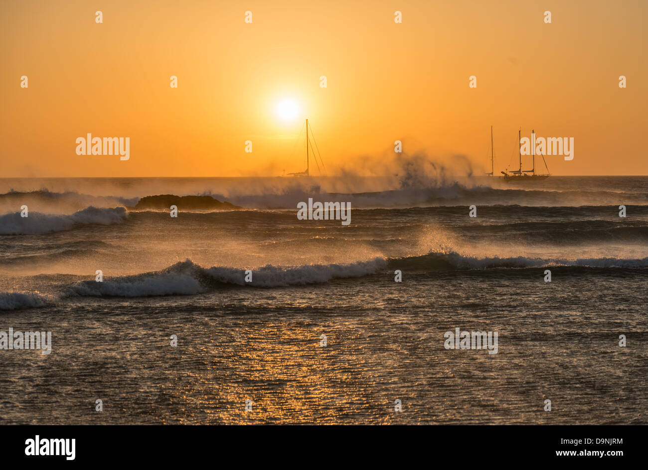 Waves breaking at sunset Stock Photo - Alamy