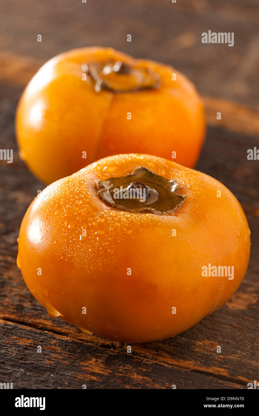 Organic Orange Persimmon Fruit against a background Stock Photo - Alamy