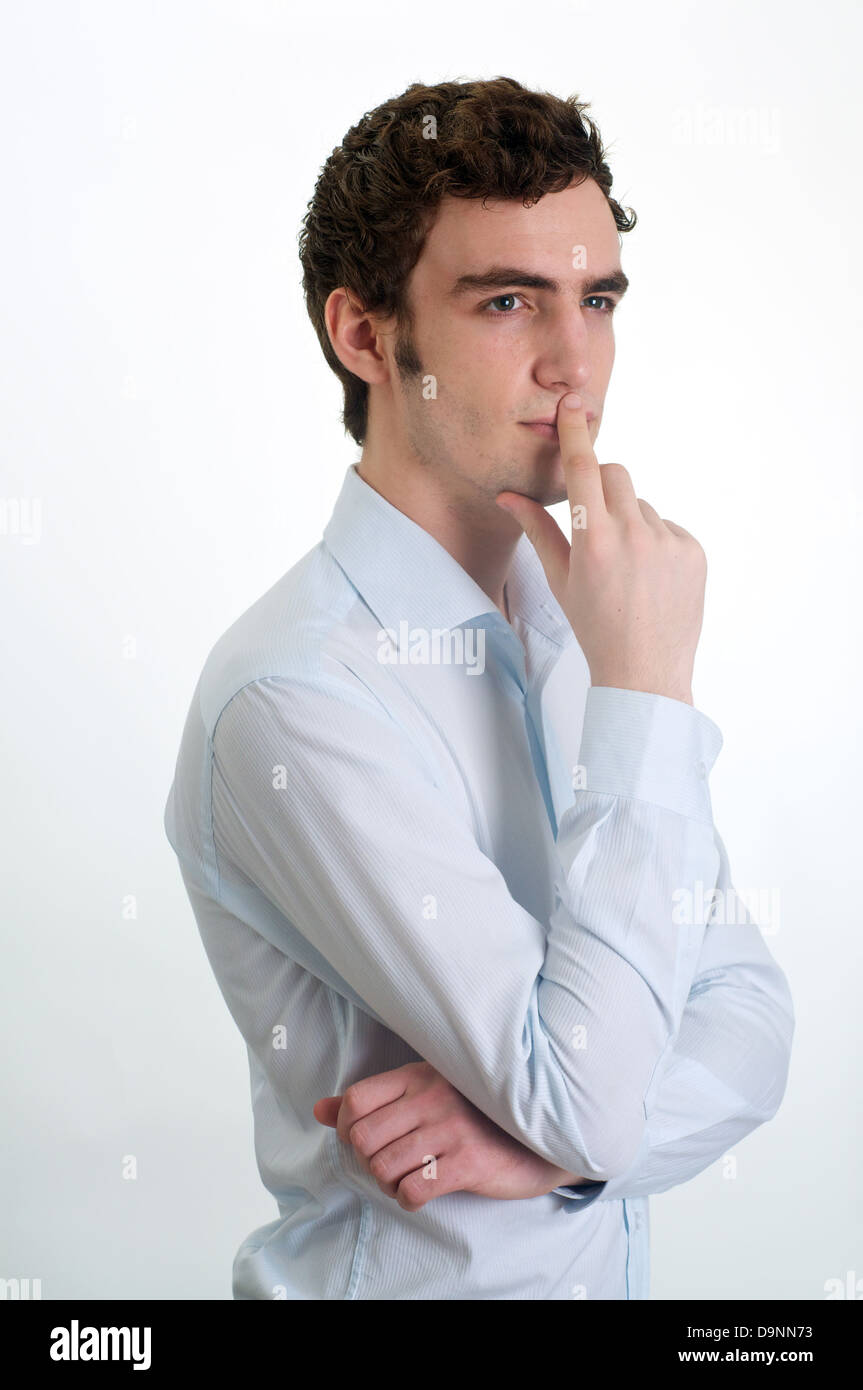 Professional young man thinking, finger on lips Stock Photo - Alamy