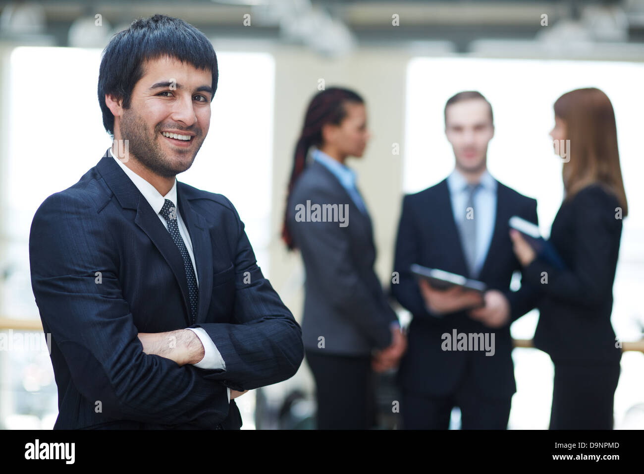 Portrait of friendly male leader looking at camera in working ...