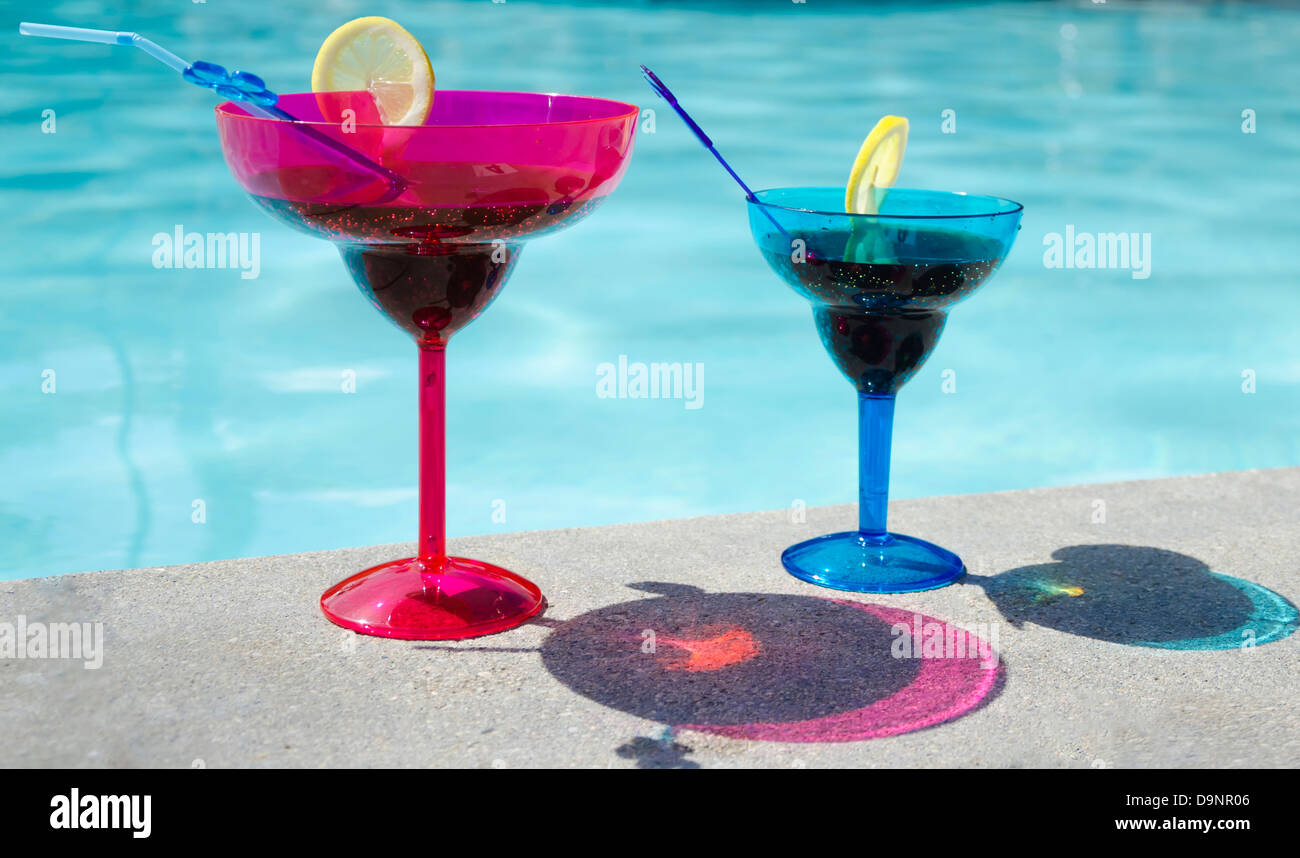 Two drinks in color glass by the swimming pool Stock Photo - Alamy