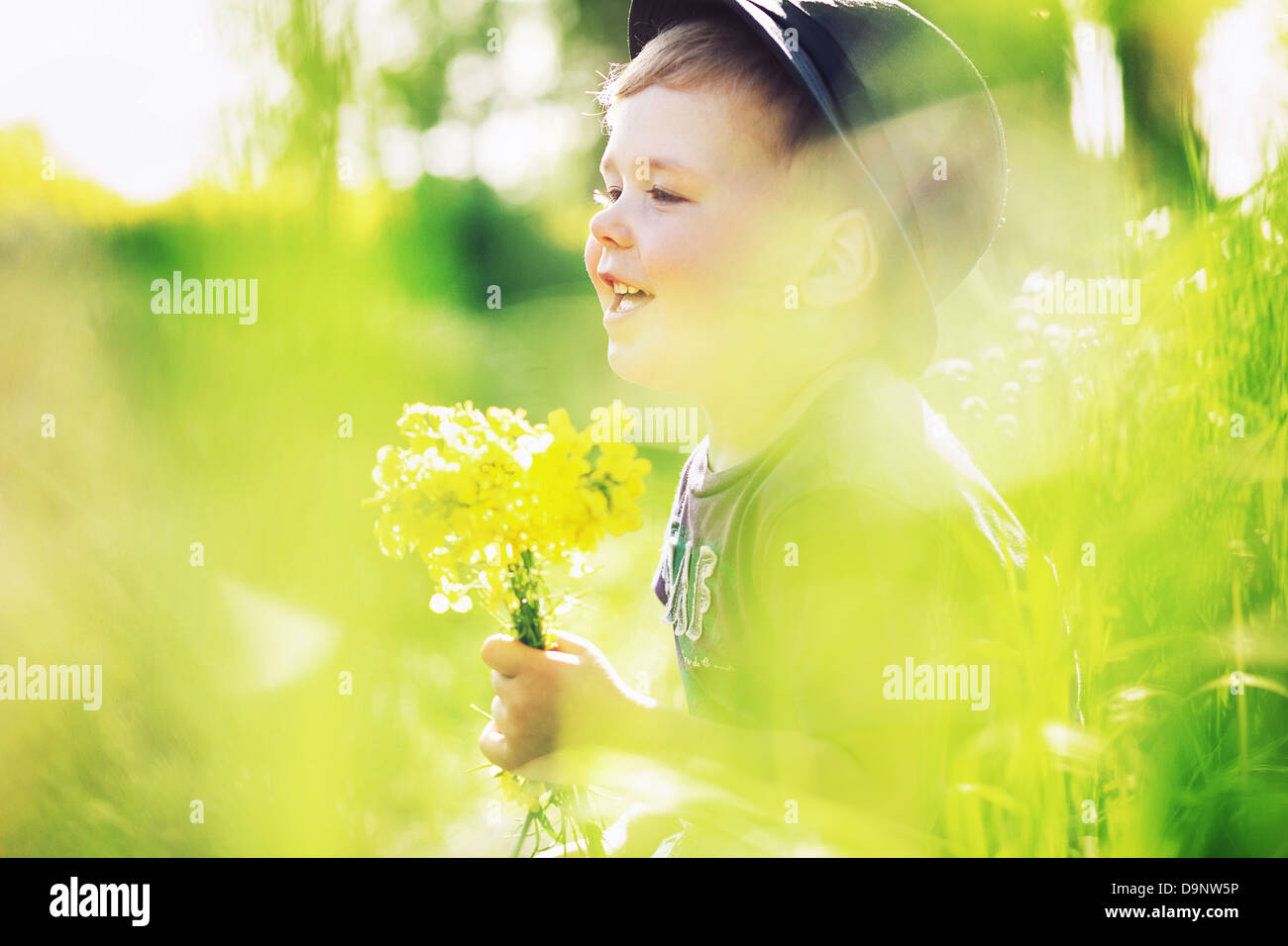 Smiling kid holding yellow flowers Stock Photo - Alamy