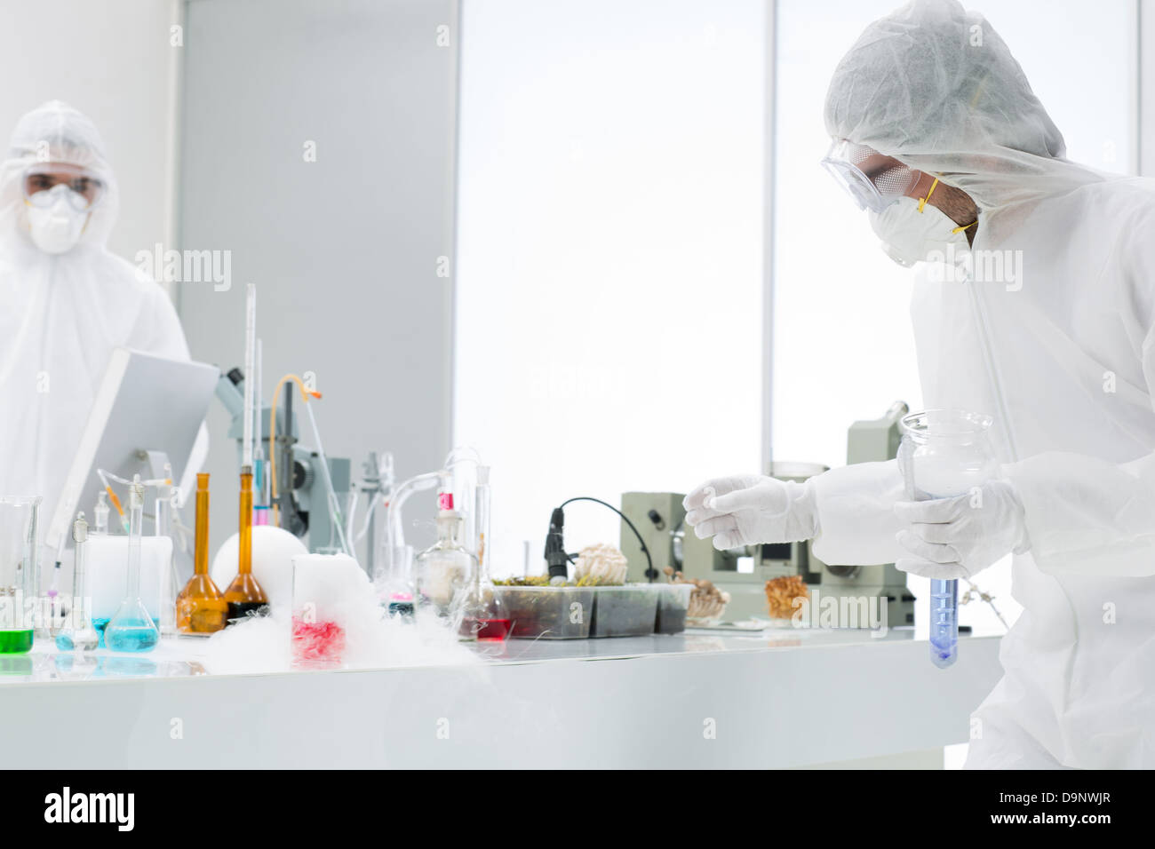 side-view of people working in a laboratory with lab tools and colorful ...