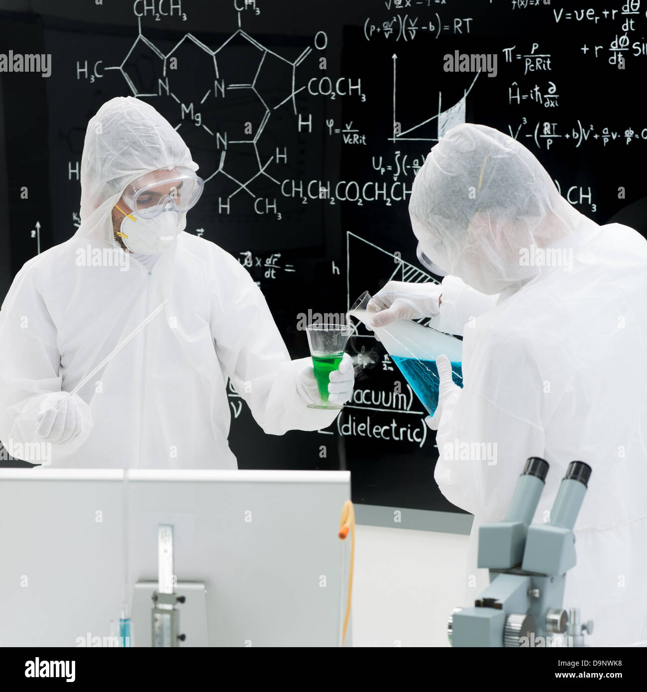 side-view of two peopleconducting a laboratory experiment with colorful ...