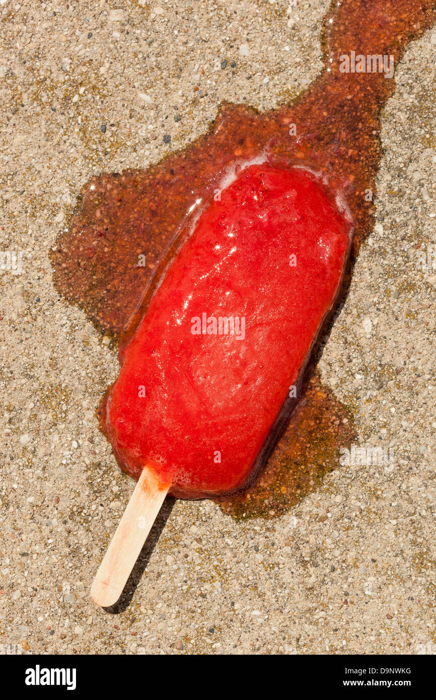 Cold Organic Frozen Strawberry Fruit Popsicle melted on the Ground ...