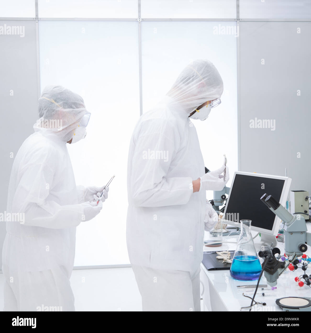 side-view of people working in a chemistry lab around a lab table with ...