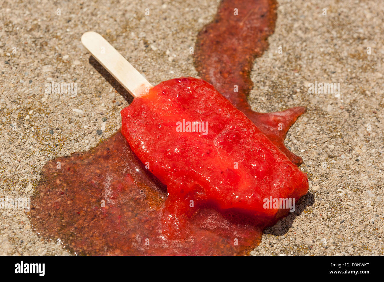 Cold Organic Frozen Strawberry Fruit Popsicle melted on the Ground ...