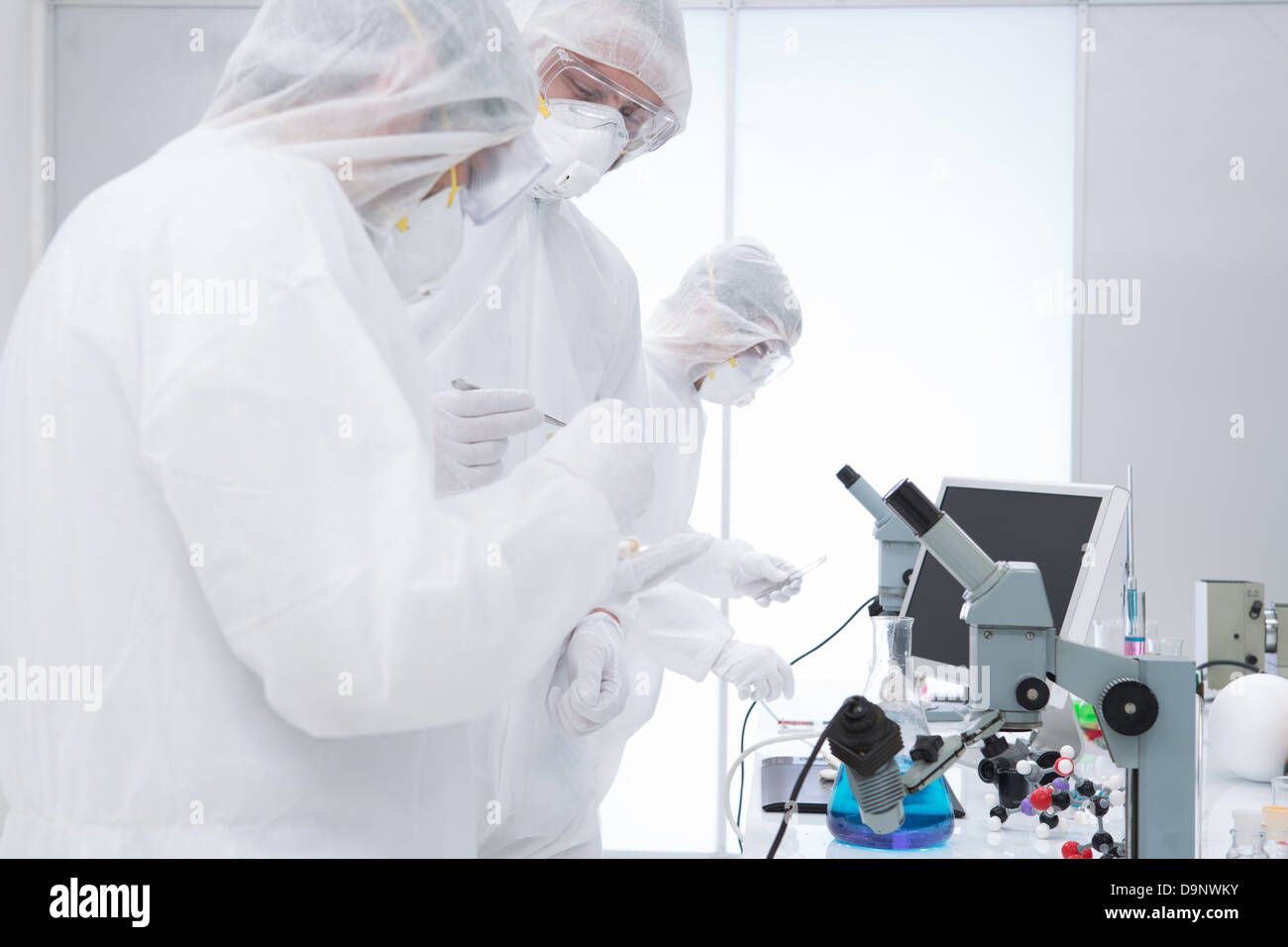 close-up of three people manipulating lab tools in a chemistry lab ...