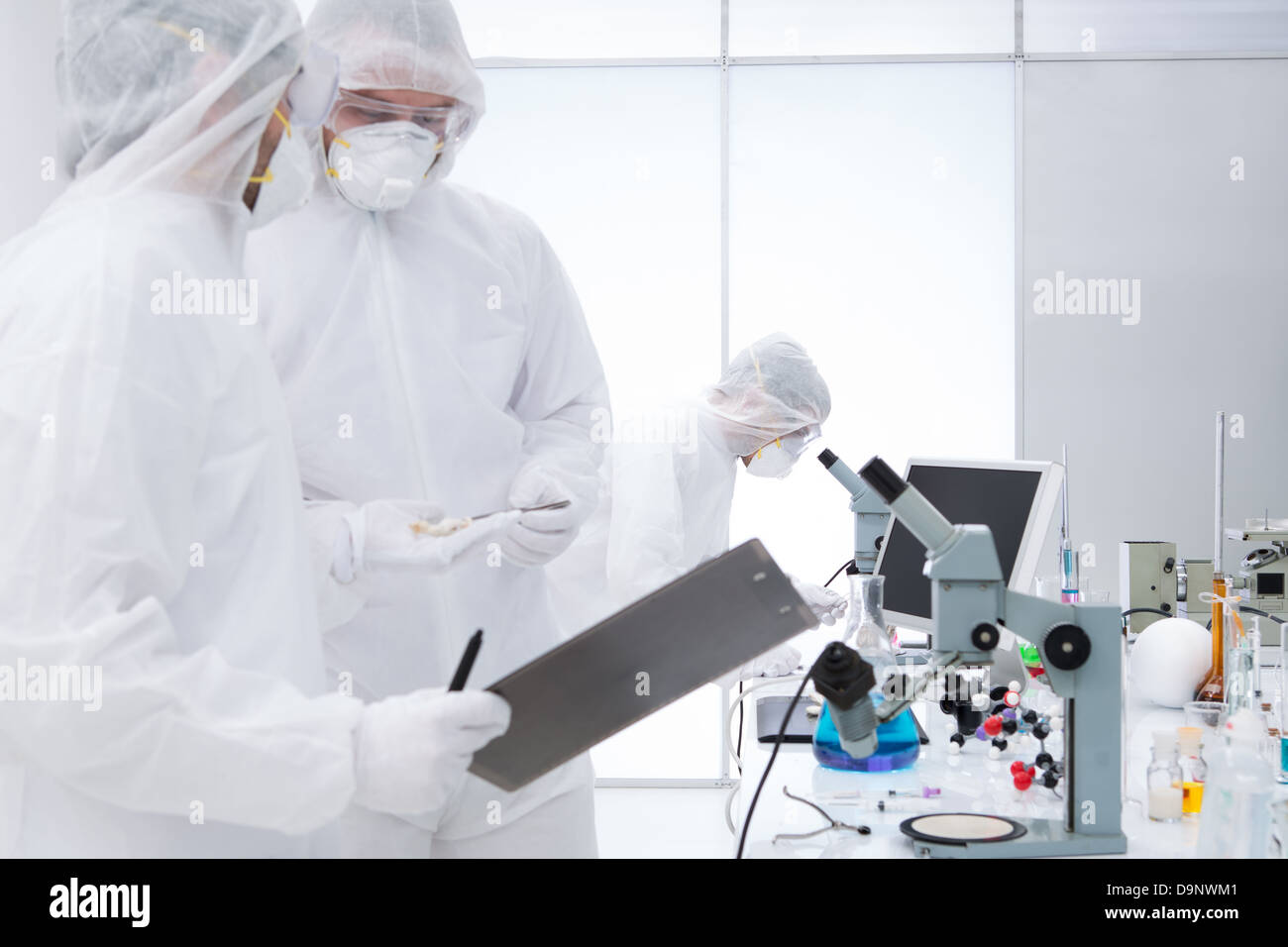 close-up of people working in a chemistry lab evaluating and comparing ...