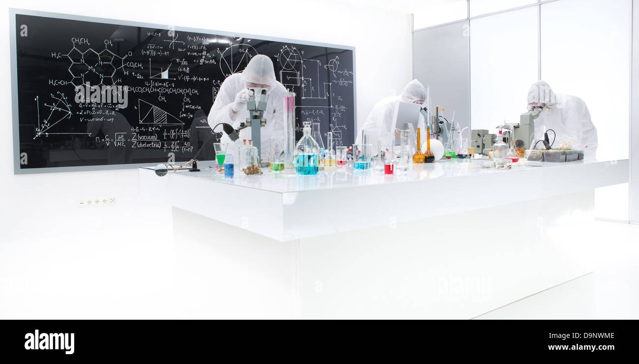 side-view of people working in a chemistry lab around a lab table with ...