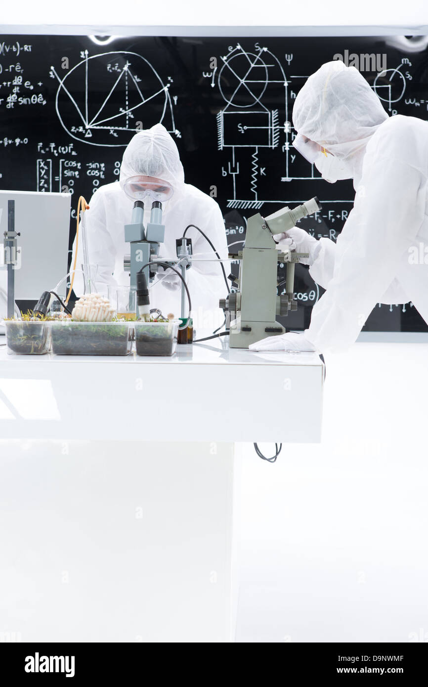 side-view of people working in a chemistry lab around a lab table with ...