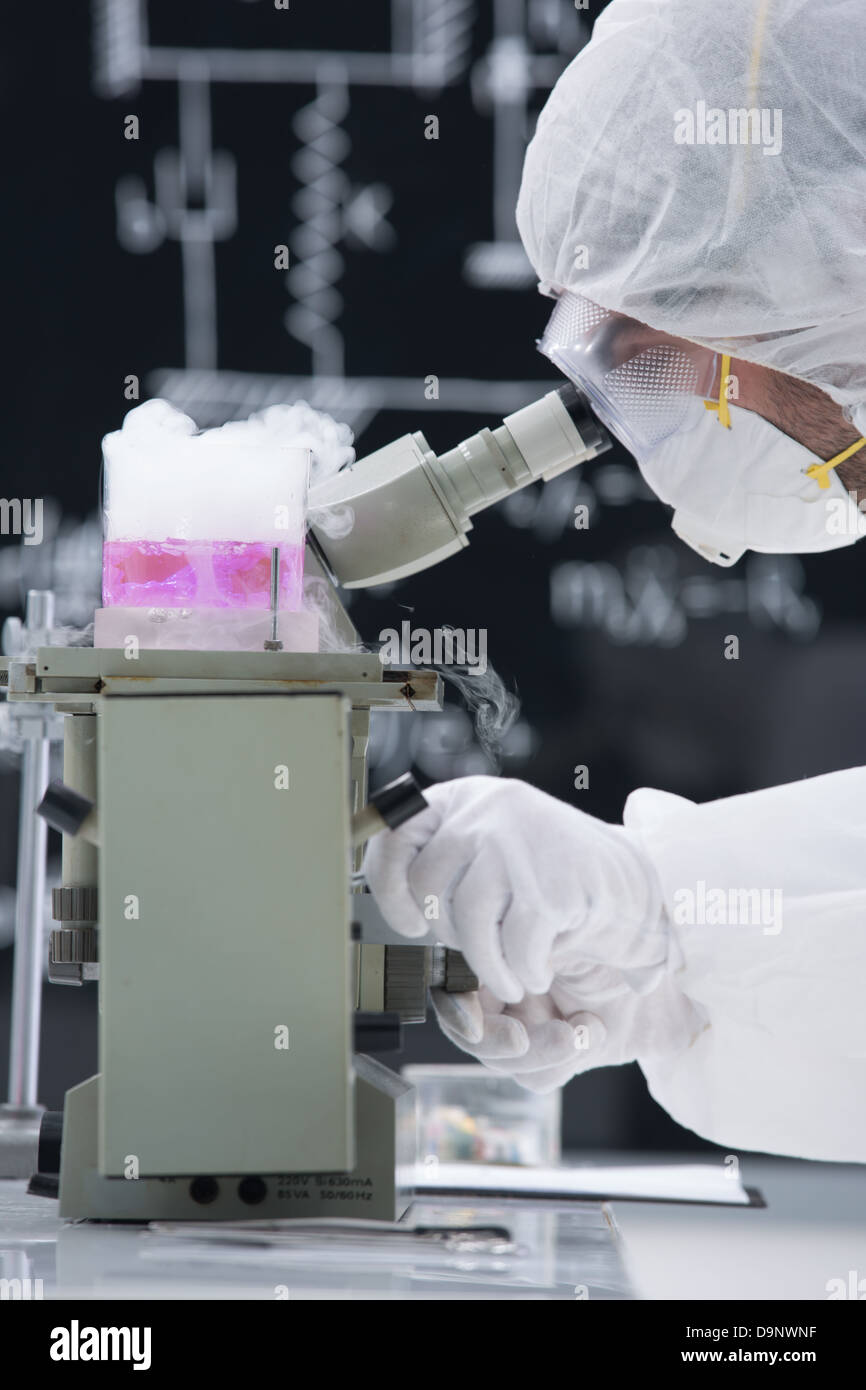 close-up of scientist in a chemistry lab analyzing under microscope ...