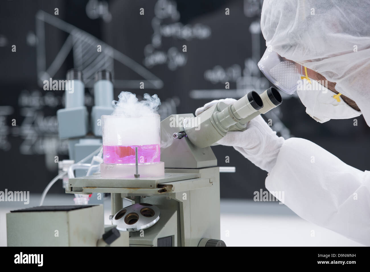 close-up of scientist analyzing under microscope in a chemistry lab ...