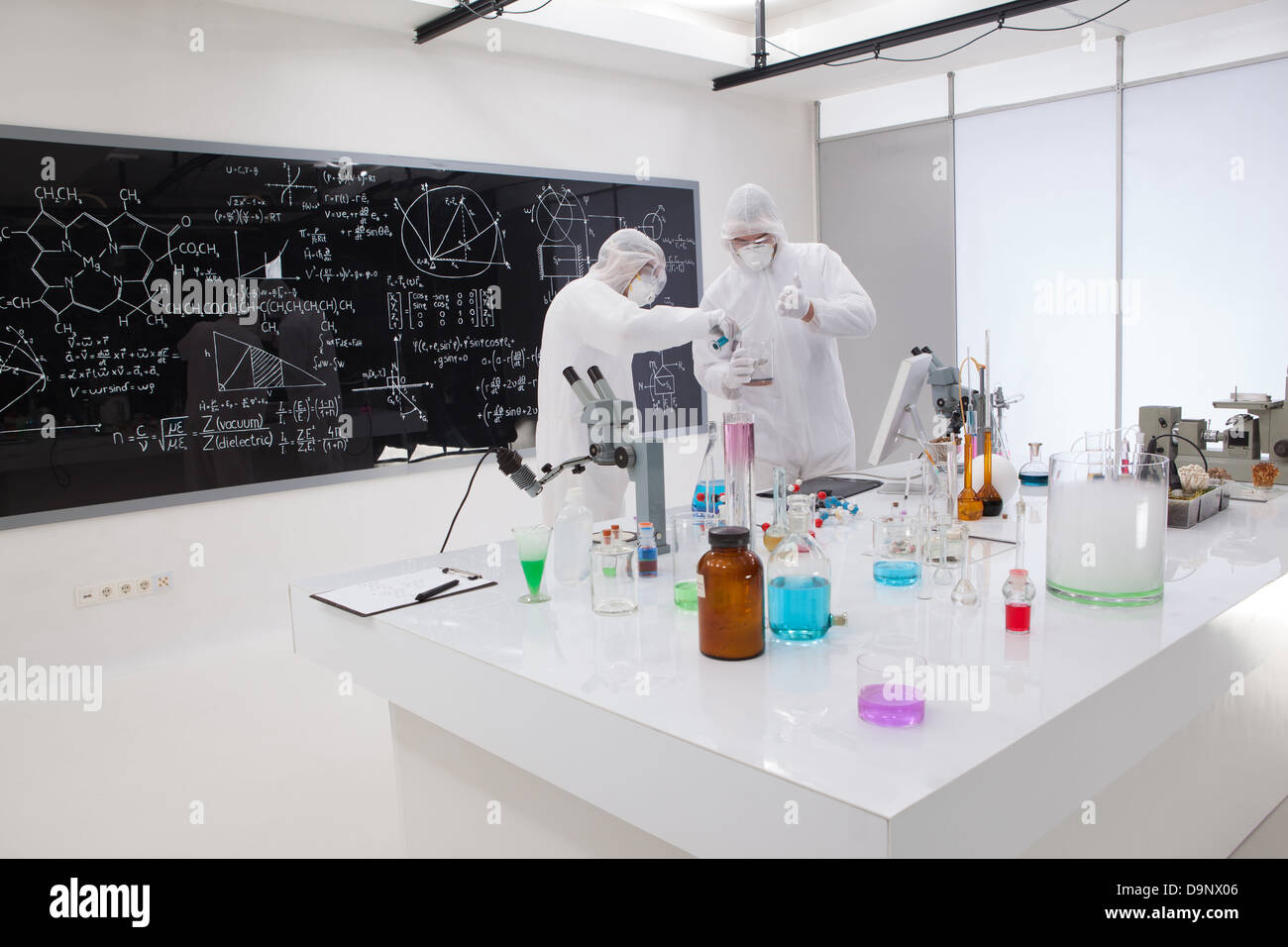 general view of two people making a laboratory experiment around a ...