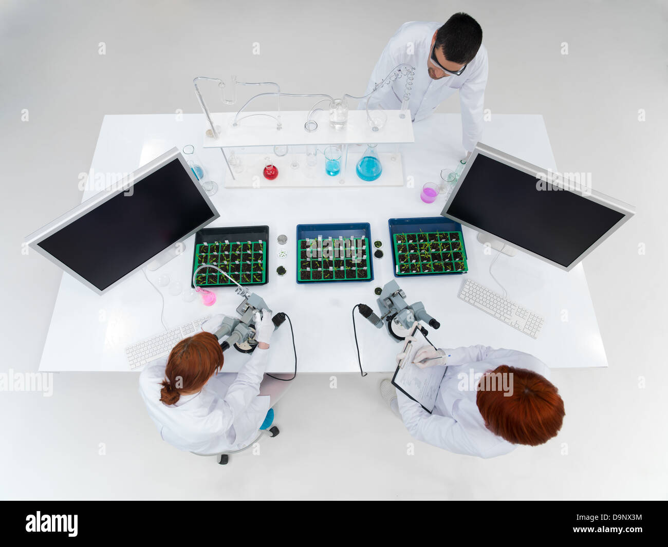 upper-view of a teacher in a chemistry lab supervising the activity of ...