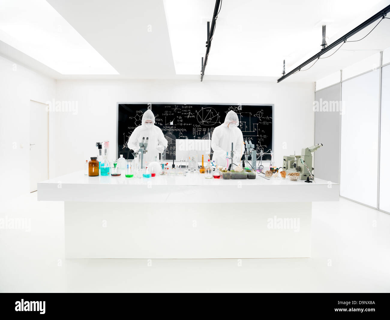 close-up of two scientists in a chemistry lab conducting an experiment ...