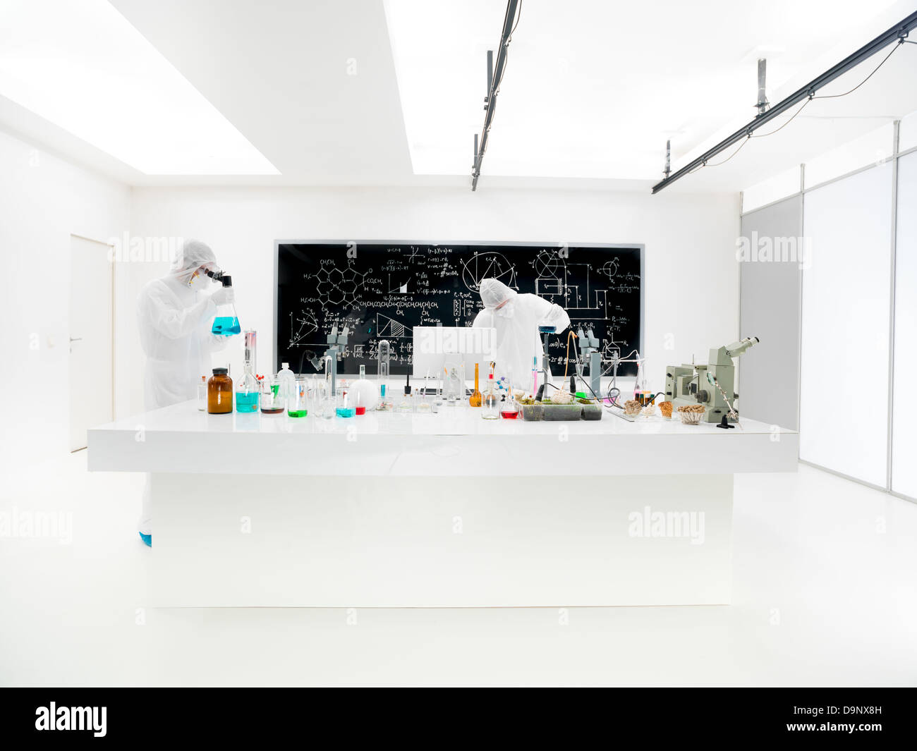 close-up of two scientists in a chemistry lab conducting an experiment ...