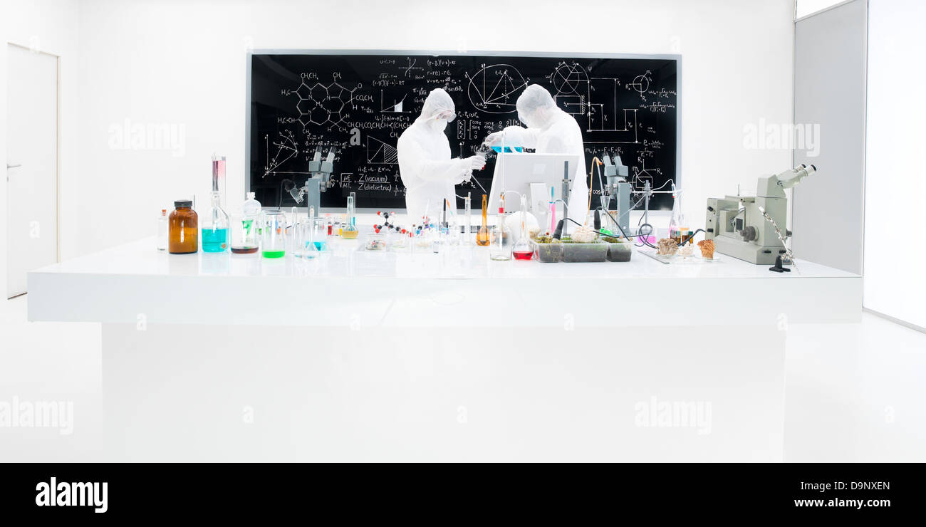 close-up of two scientists in a chemistry lab conducting an experiment ...