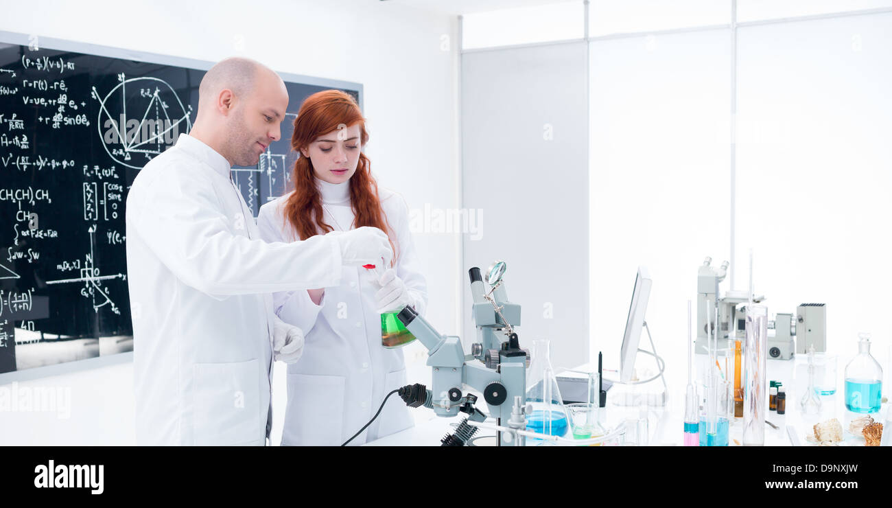 side-view of a teacher conducting a lab experiment with a student ...